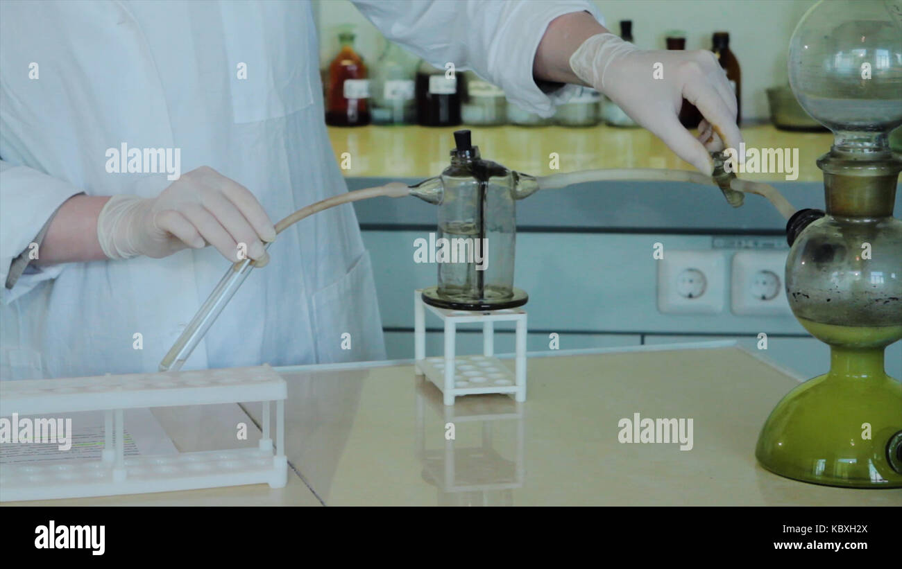 Close-up partial view of scientists making experiment with reagent and ...