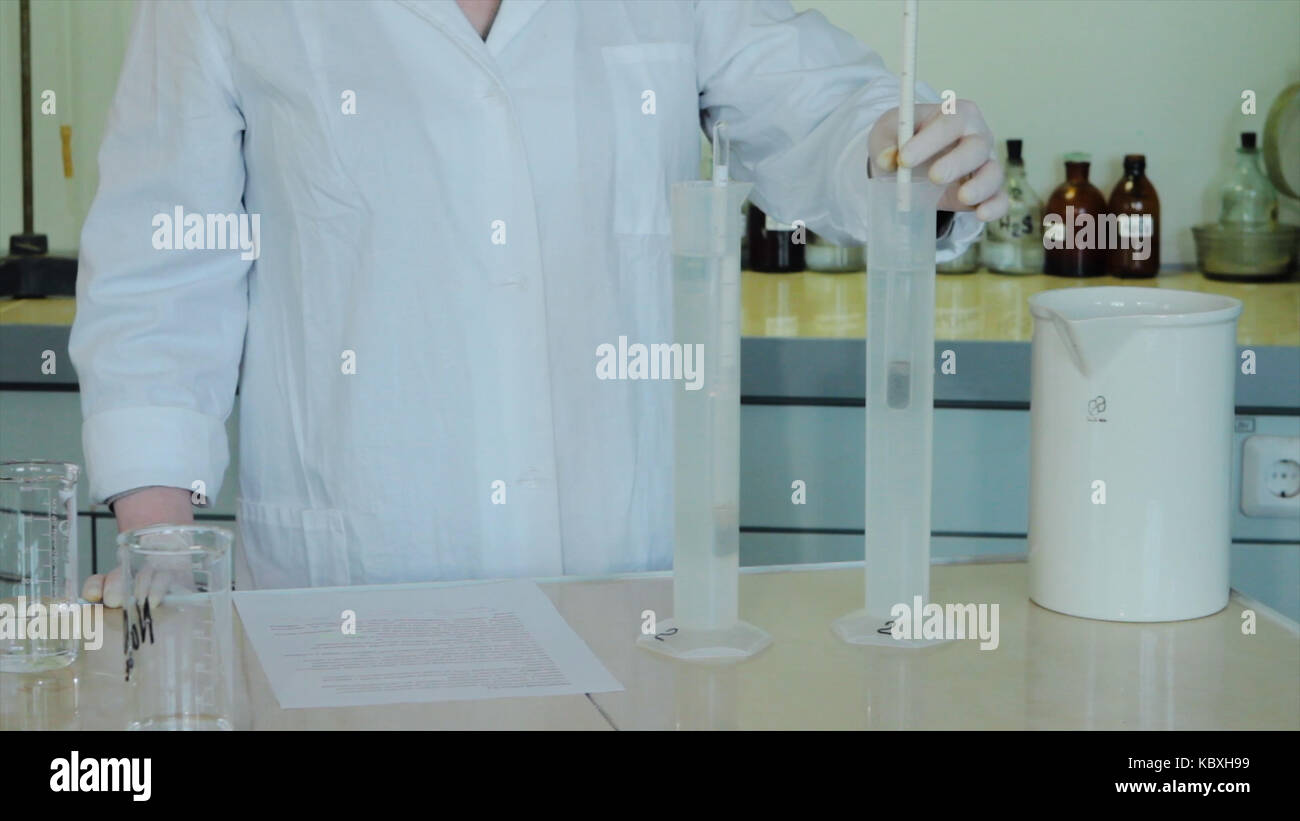 Close-up partial view of scientists making experiment with reagent and ...