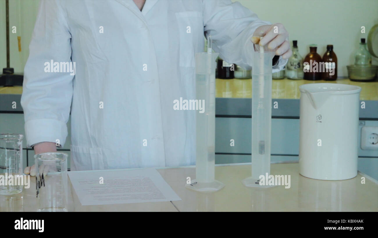 Close-up partial view of scientists making experiment with reagent and ...