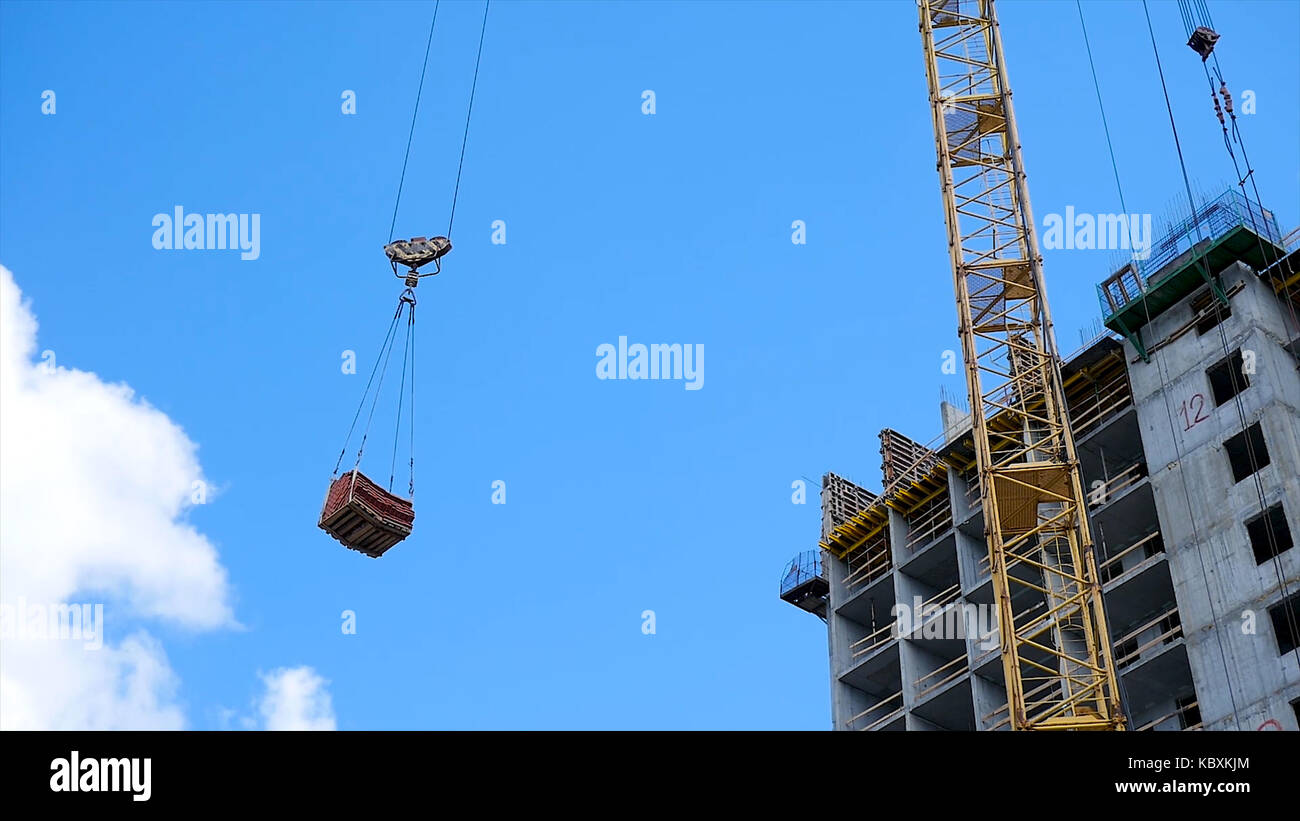 Crane and building construction site against blue sky. heavy load ...