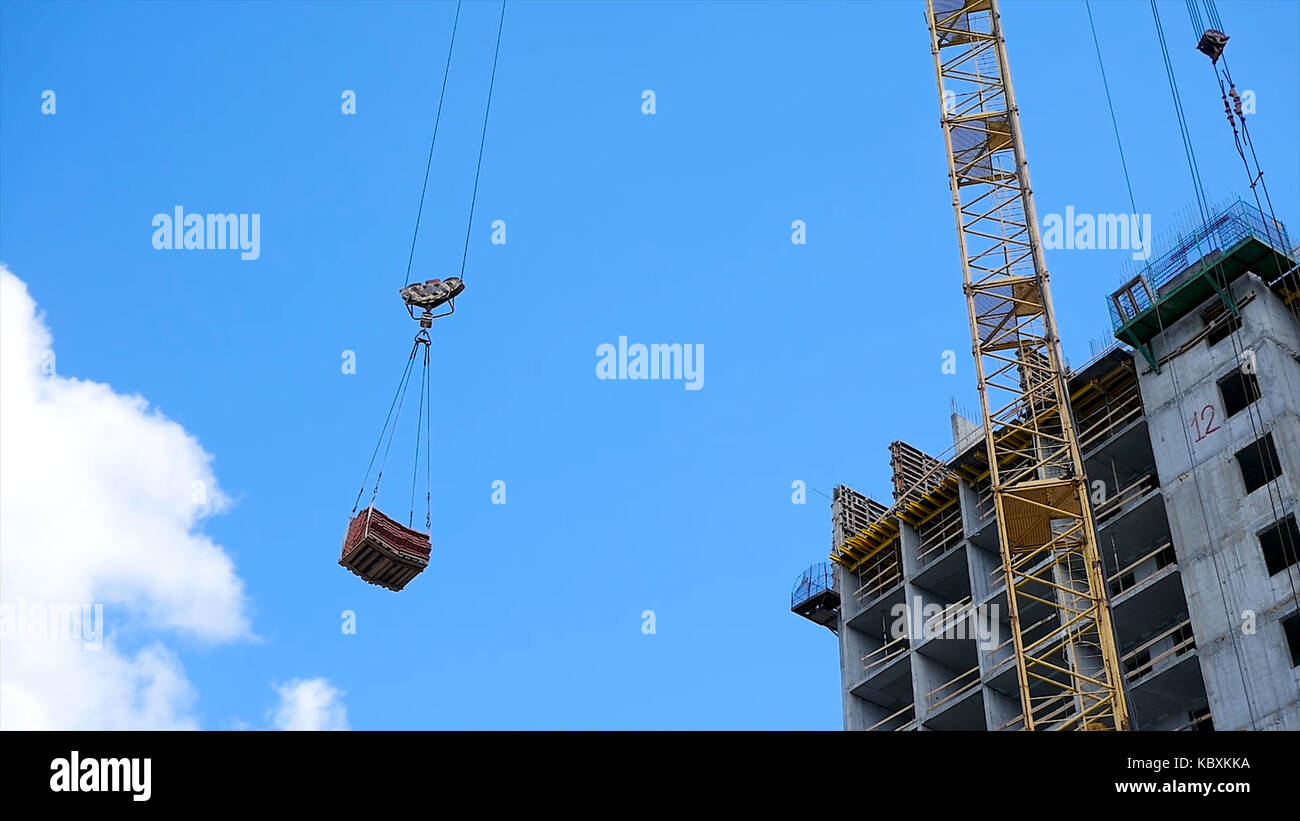 Crane and building construction site against blue sky. heavy load ...