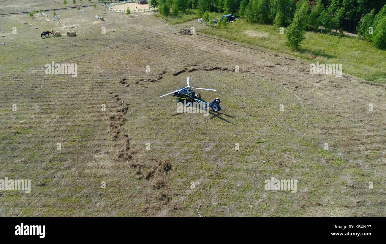 Helicopter lands in a field. Helicopter in the middle of green field ...