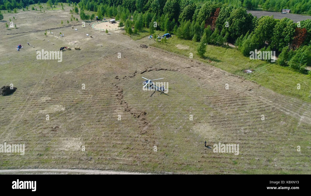 Helicopter lands in a field. Helicopter in the middle of green field ...