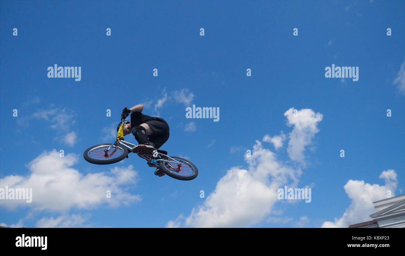 Young man on BMX bike jumps. Man doing twists and tricks on bmx in slow ...