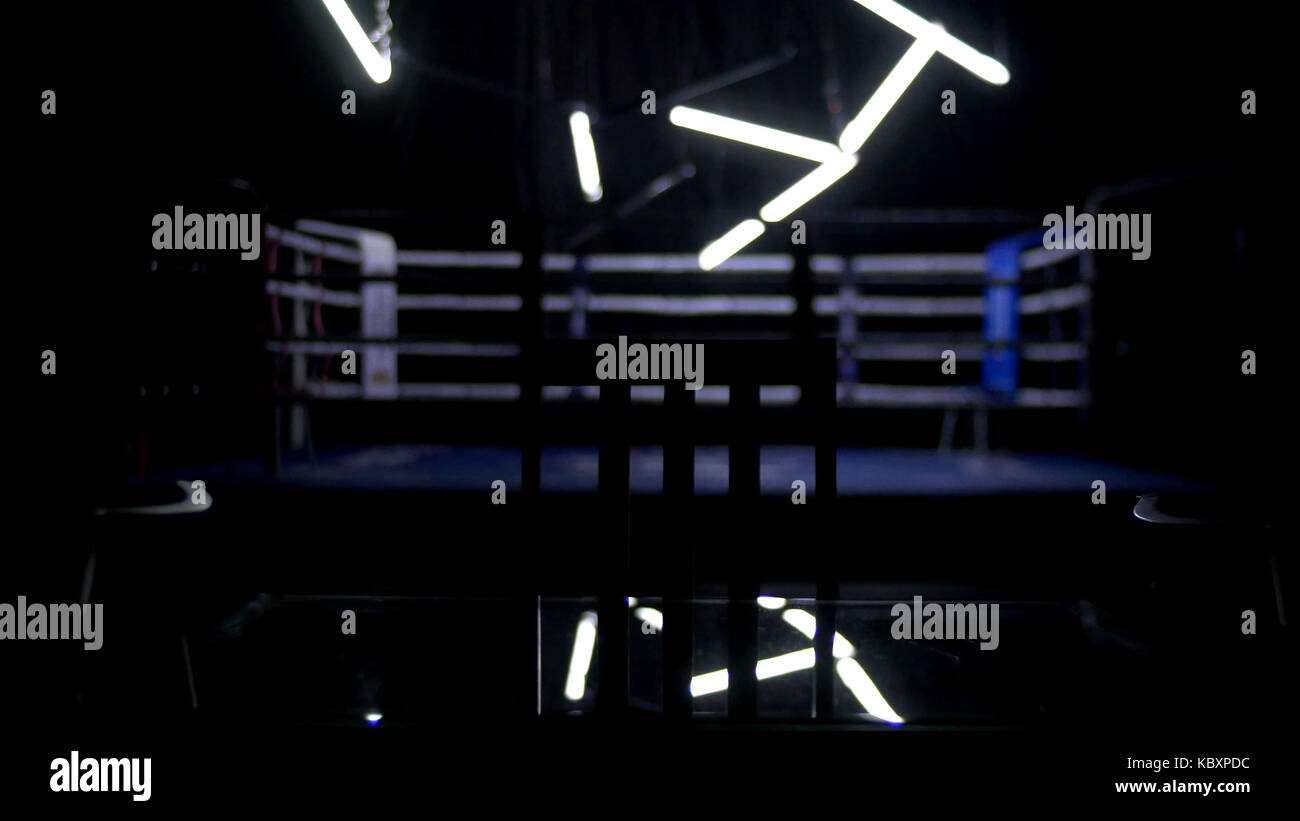 Boxing ring and two chairs with table dark background. View of a ...