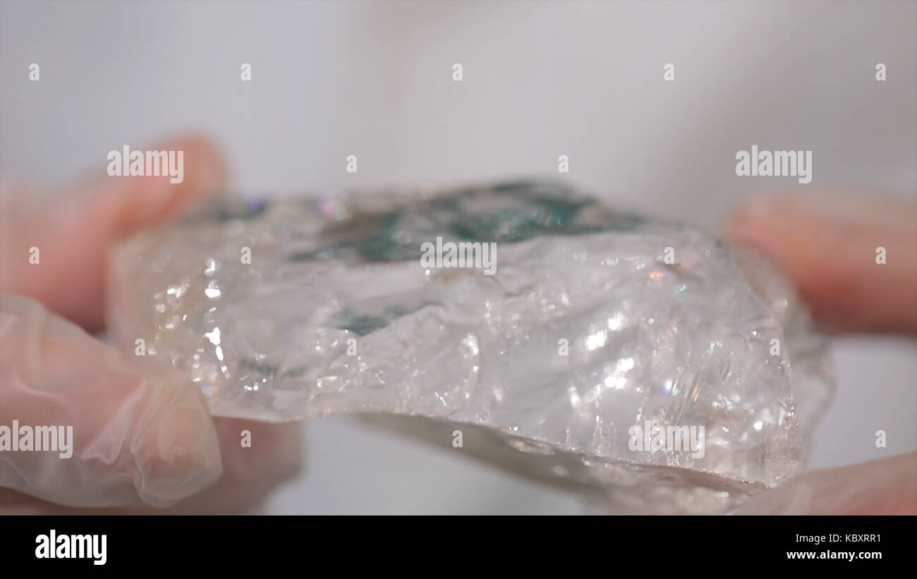 Scientist holding sample of raw crystal in hands. Male hand holding a ...