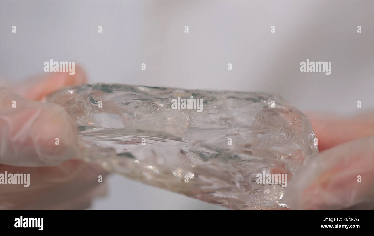 Scientist holding sample of raw crystal in hands. Male hand holding a ...