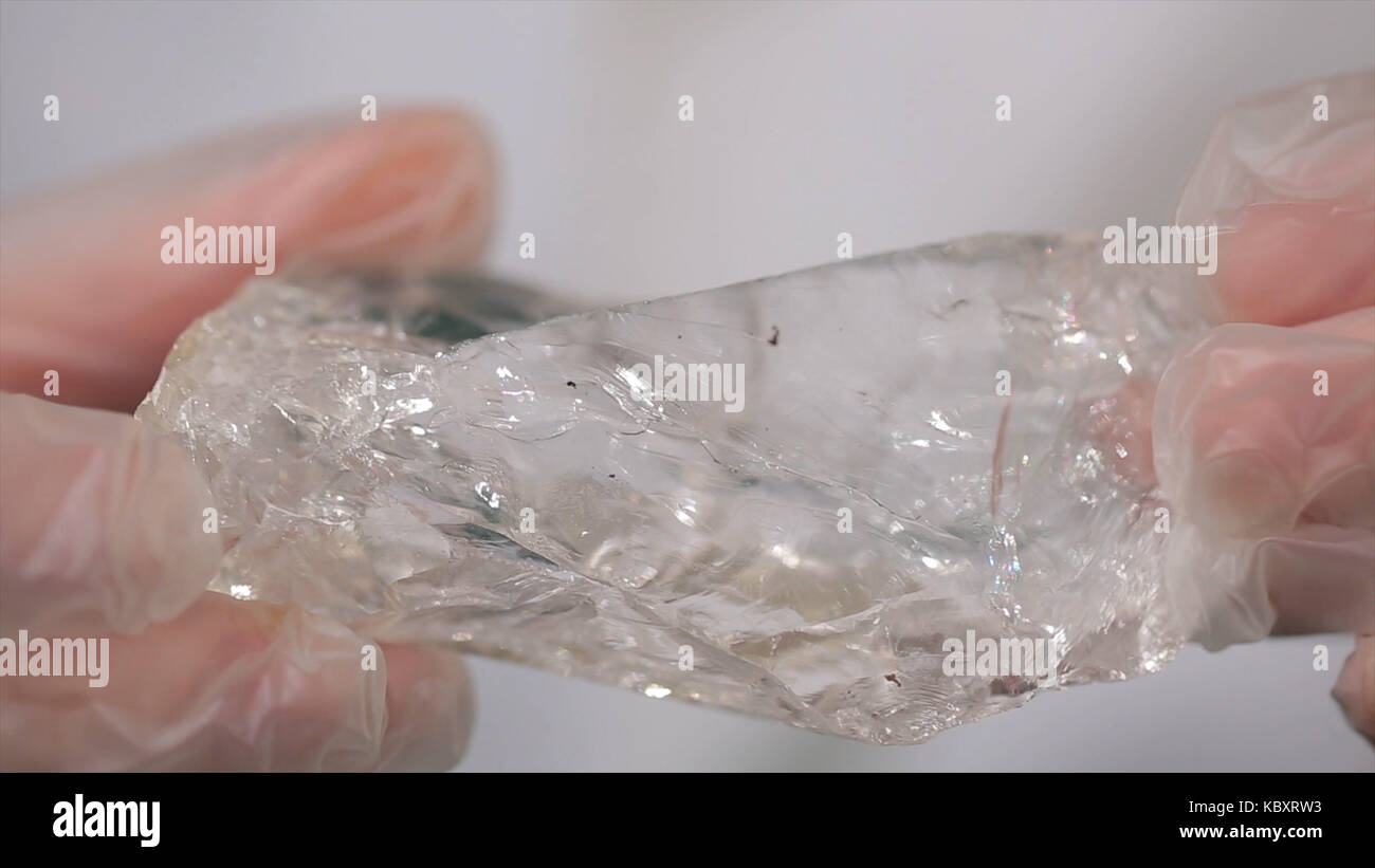 Scientist holding sample of raw crystal in hands. Male hand holding a ...