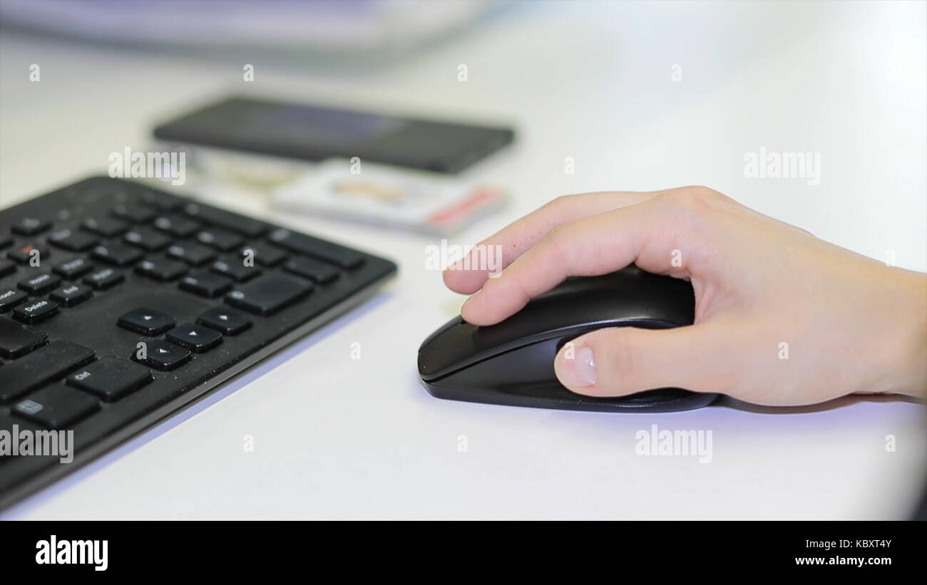 Close-up of female hand on black mouse. Woman's hand using cordless ...