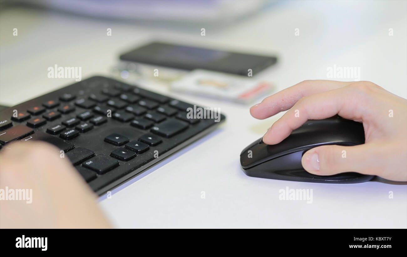 Close-up of female hand on black mouse. Woman's hand using cordless ...