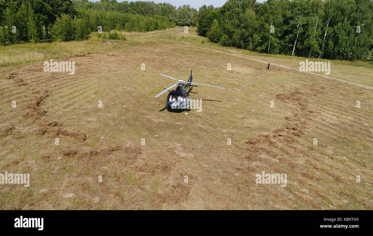 Helicopter hovering over field. Helicopter landed on the field near the ...