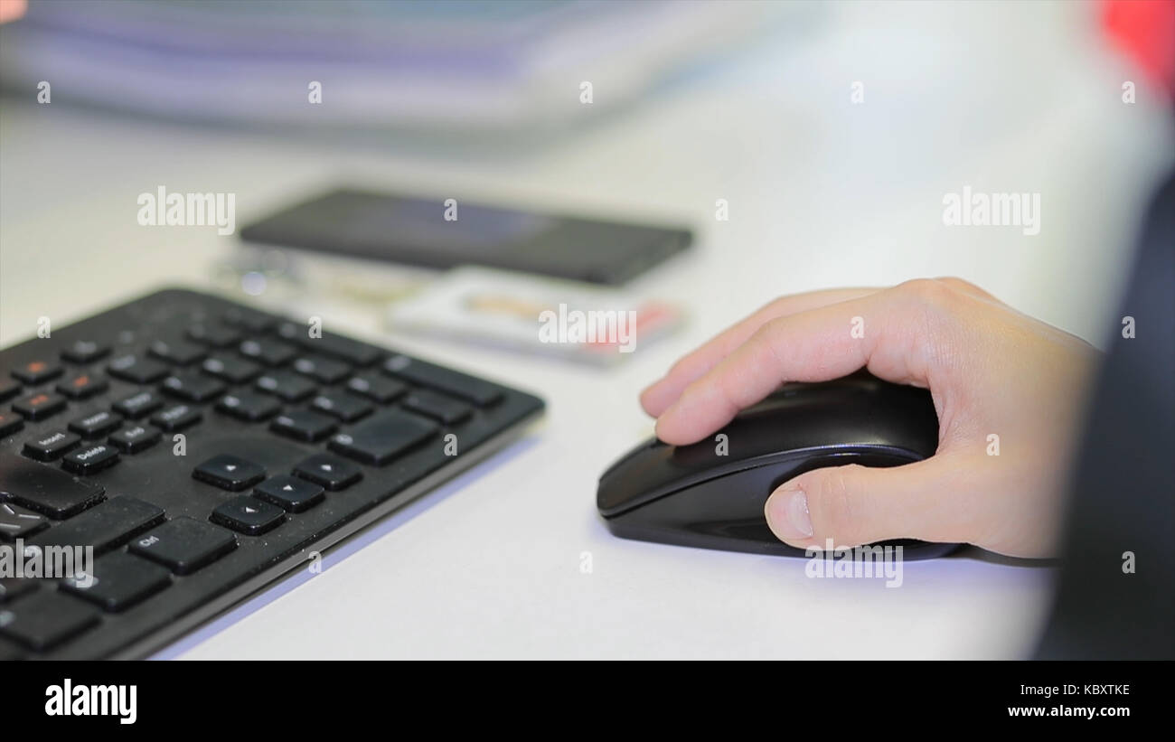 Close-up of female hand on black mouse. Woman's hand using cordless ...