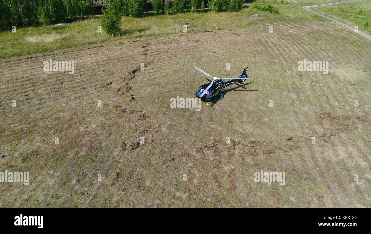 Helicopter hovering over field. Helicopter landed on the field near the ...