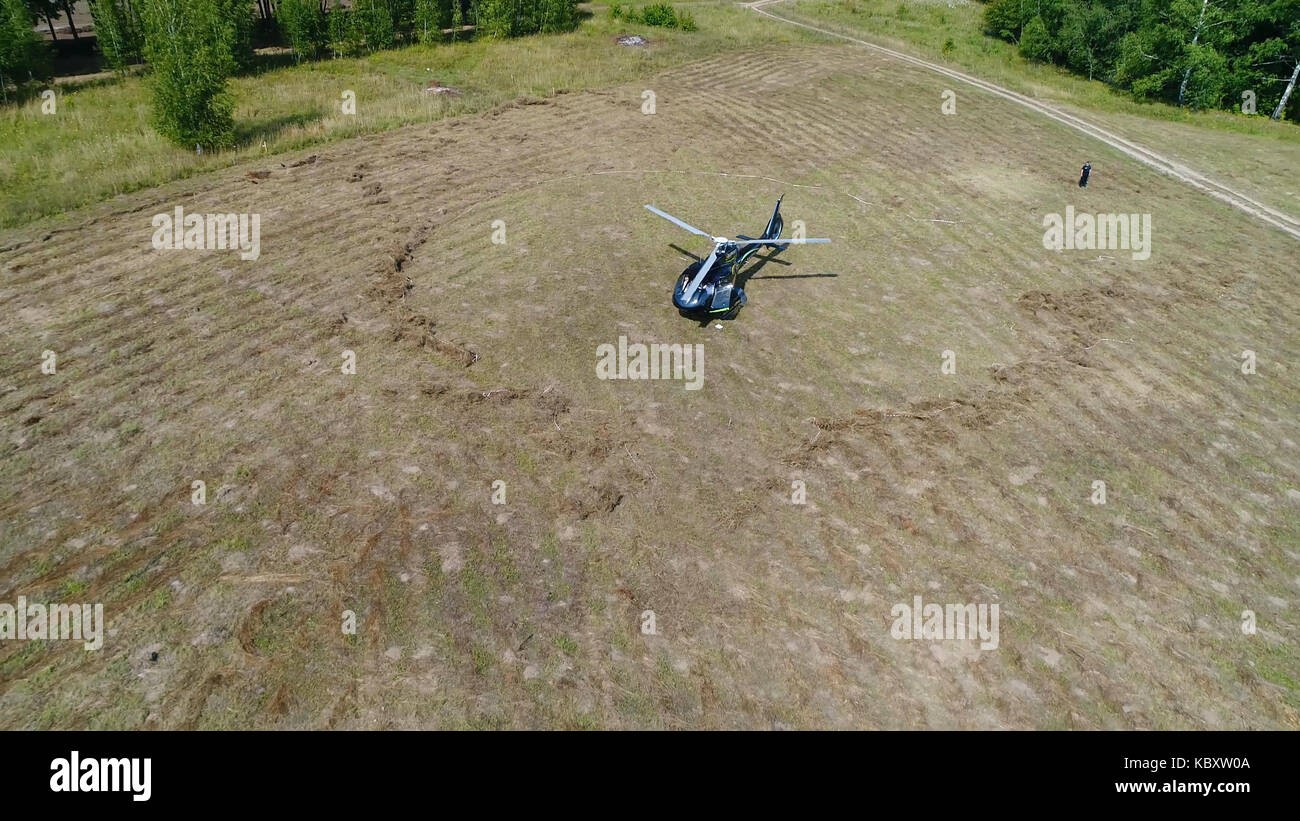 Helicopter hovering over field. Helicopter landed on the field near the ...