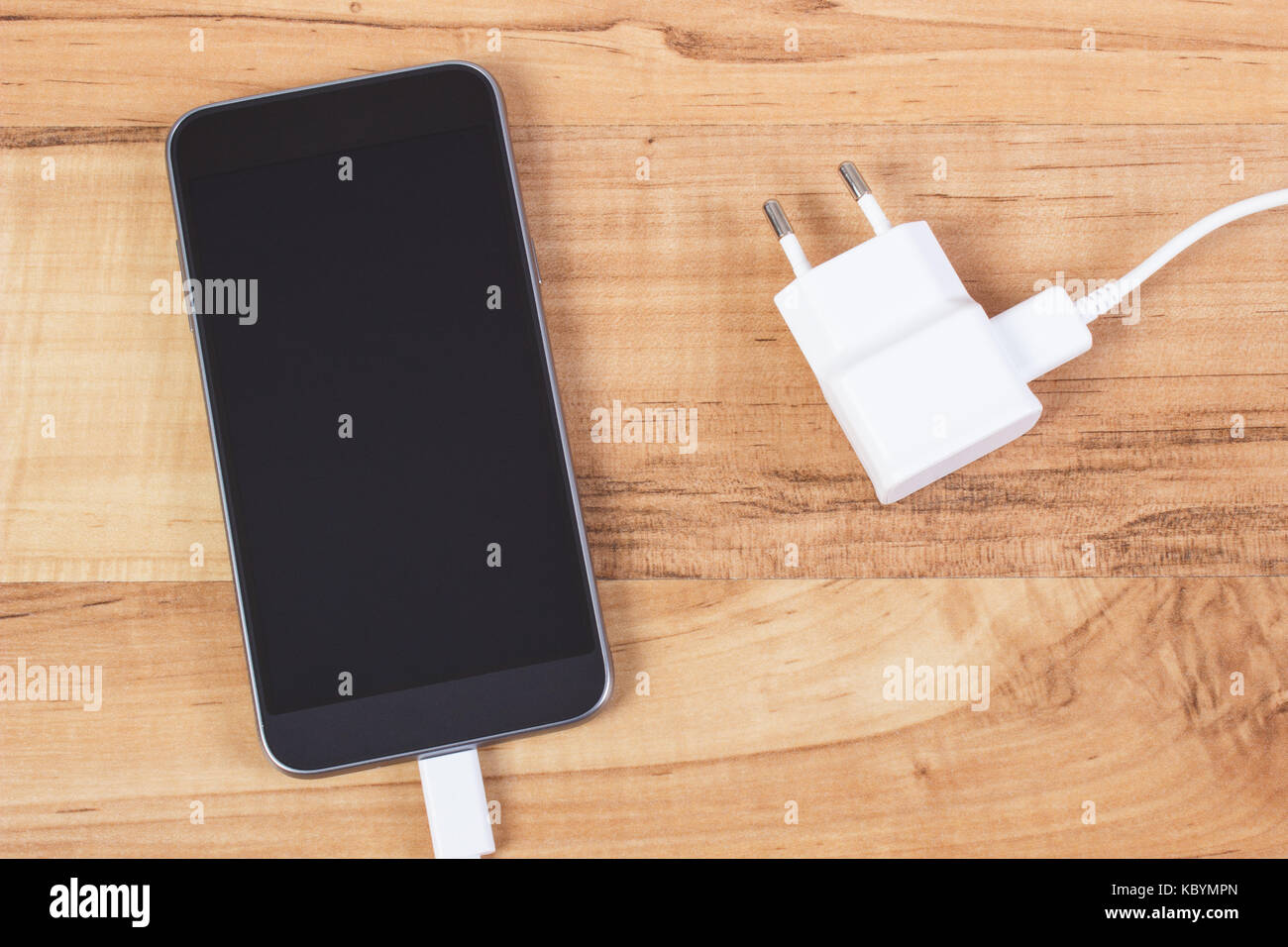 Mobile phone with connected plug of charger, smartphone charging on ...