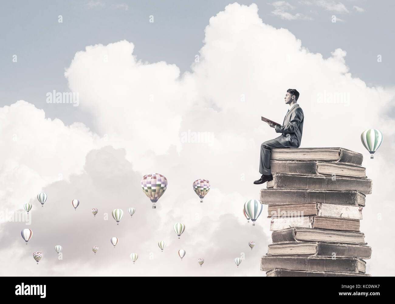 Man student reading book and aerostats flying around in air Stock Photo ...