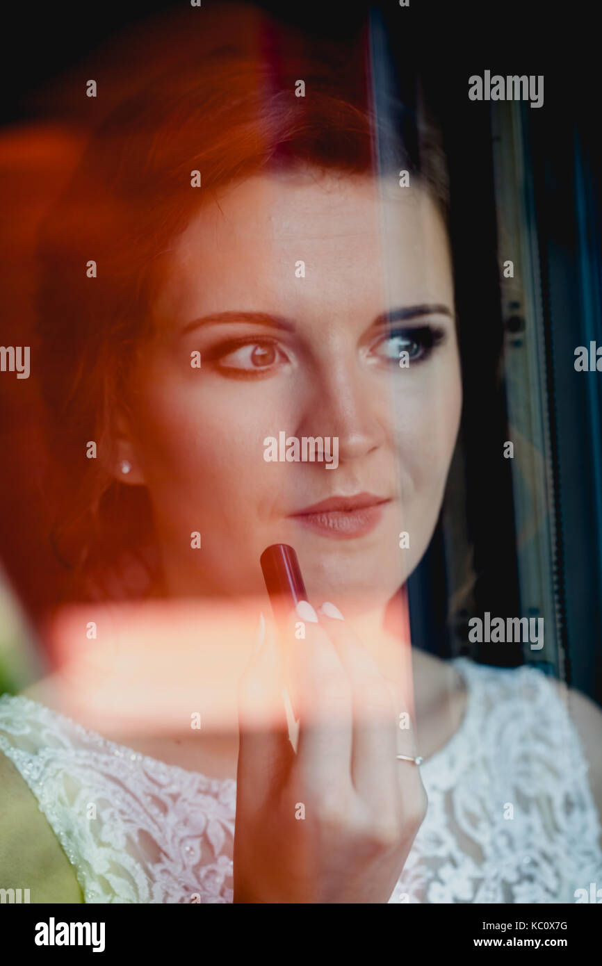 Young attractive brunette hair lady with lipstick in hand looking ...