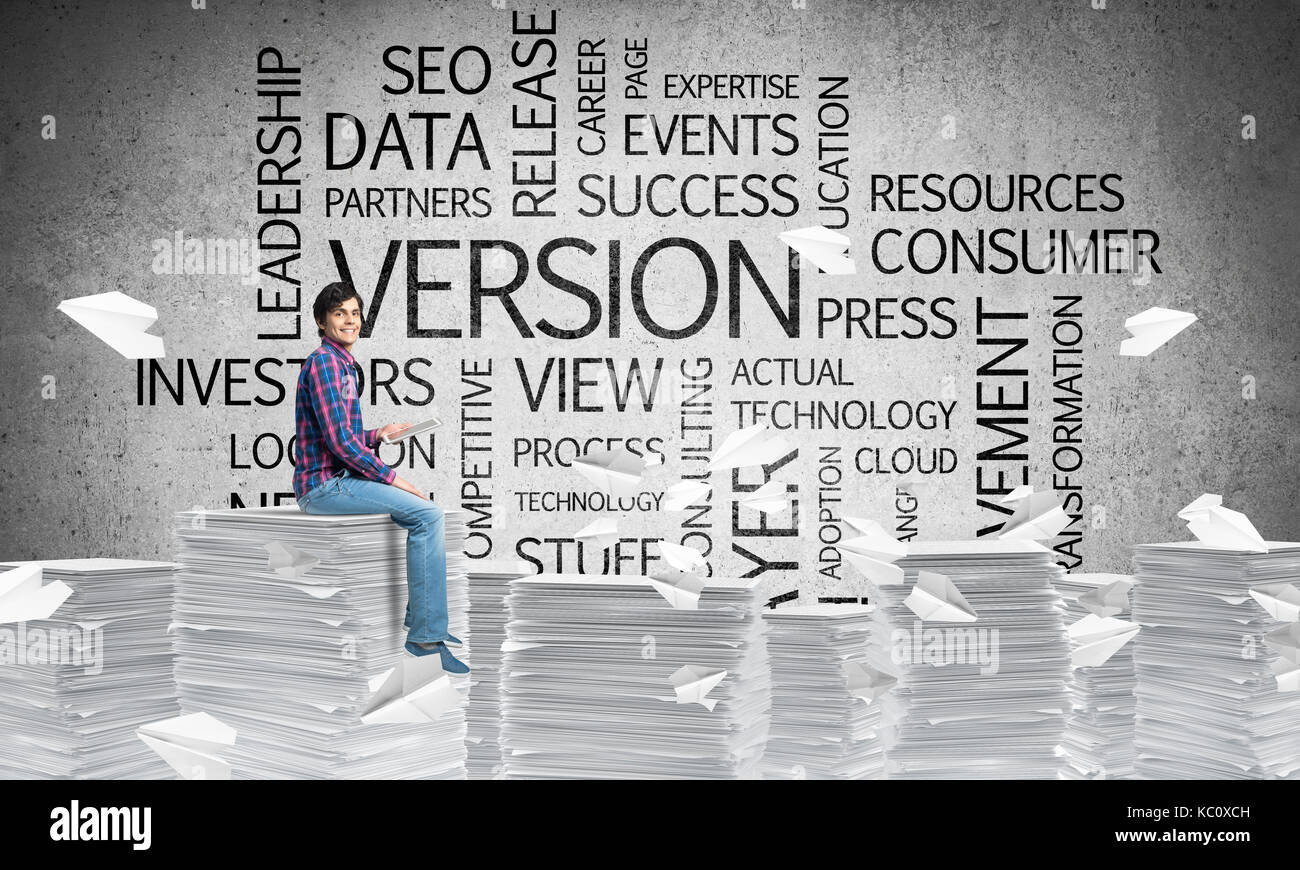 Attractive man sitting on pile of paper documents Stock Photo - Alamy