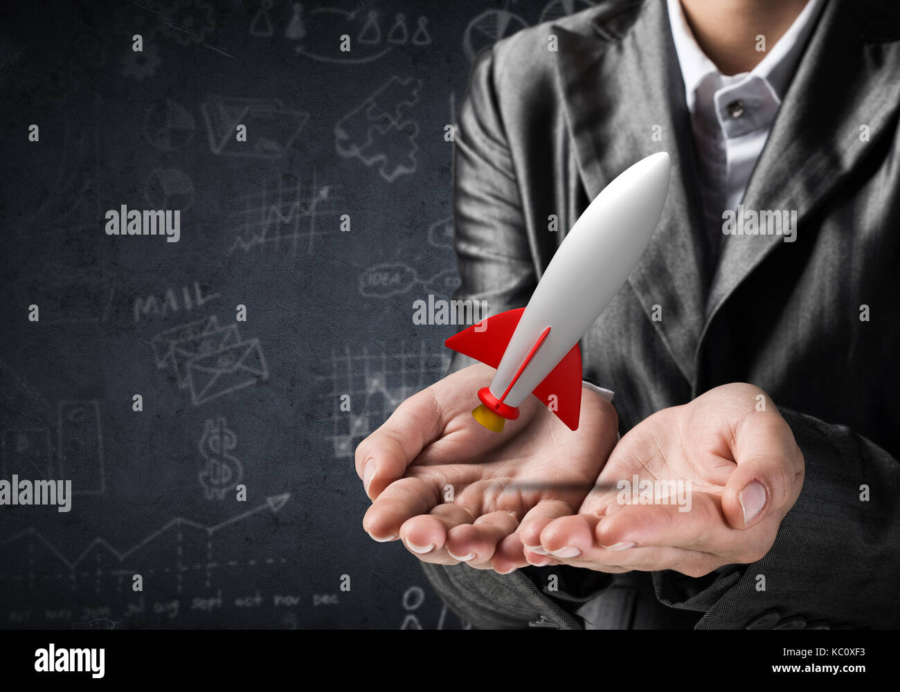 Businessman presenting rocket in hands Stock Photo - Alamy