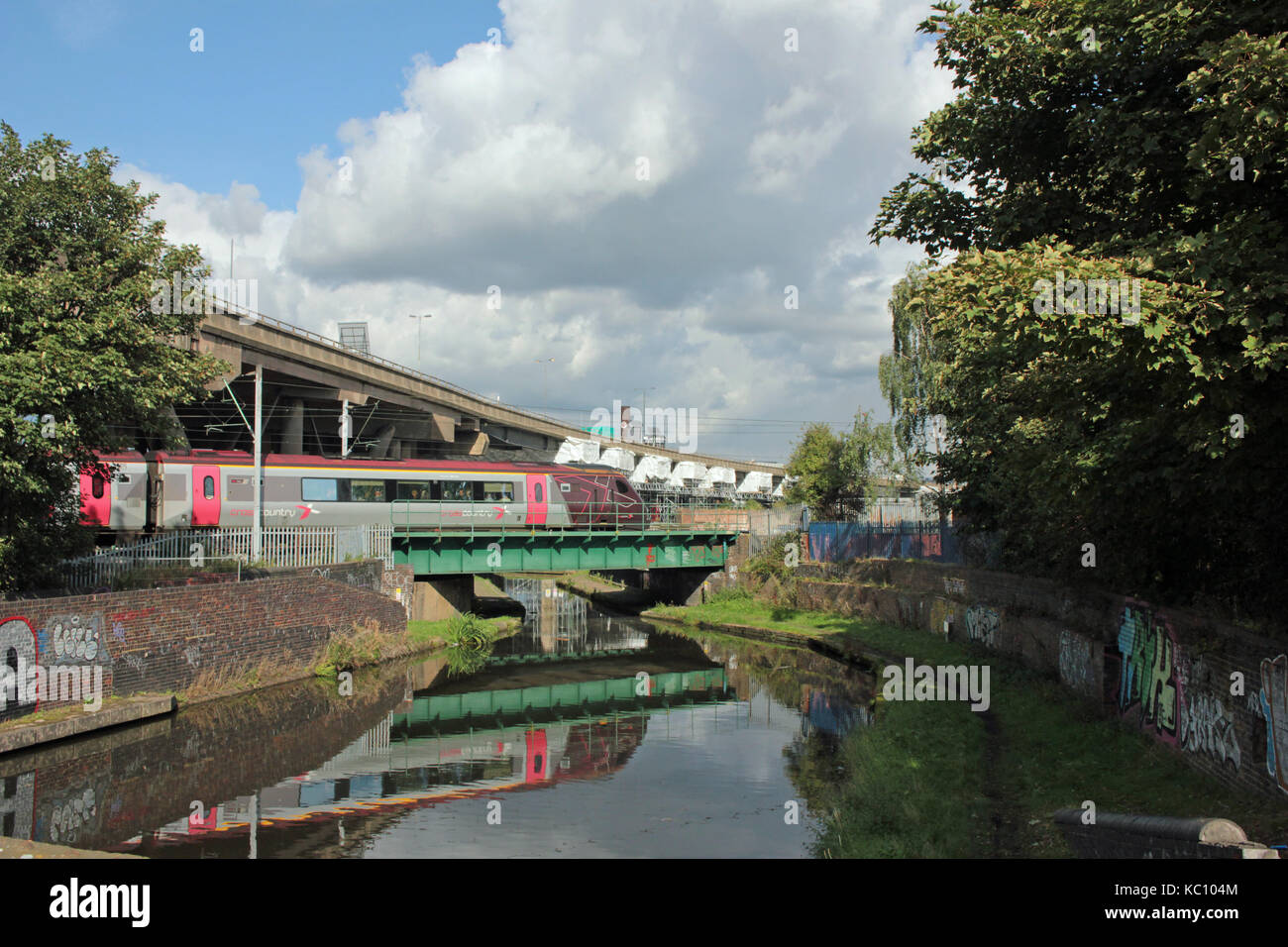 A Cross Country train is reflected in the water as it crosses a canal ...