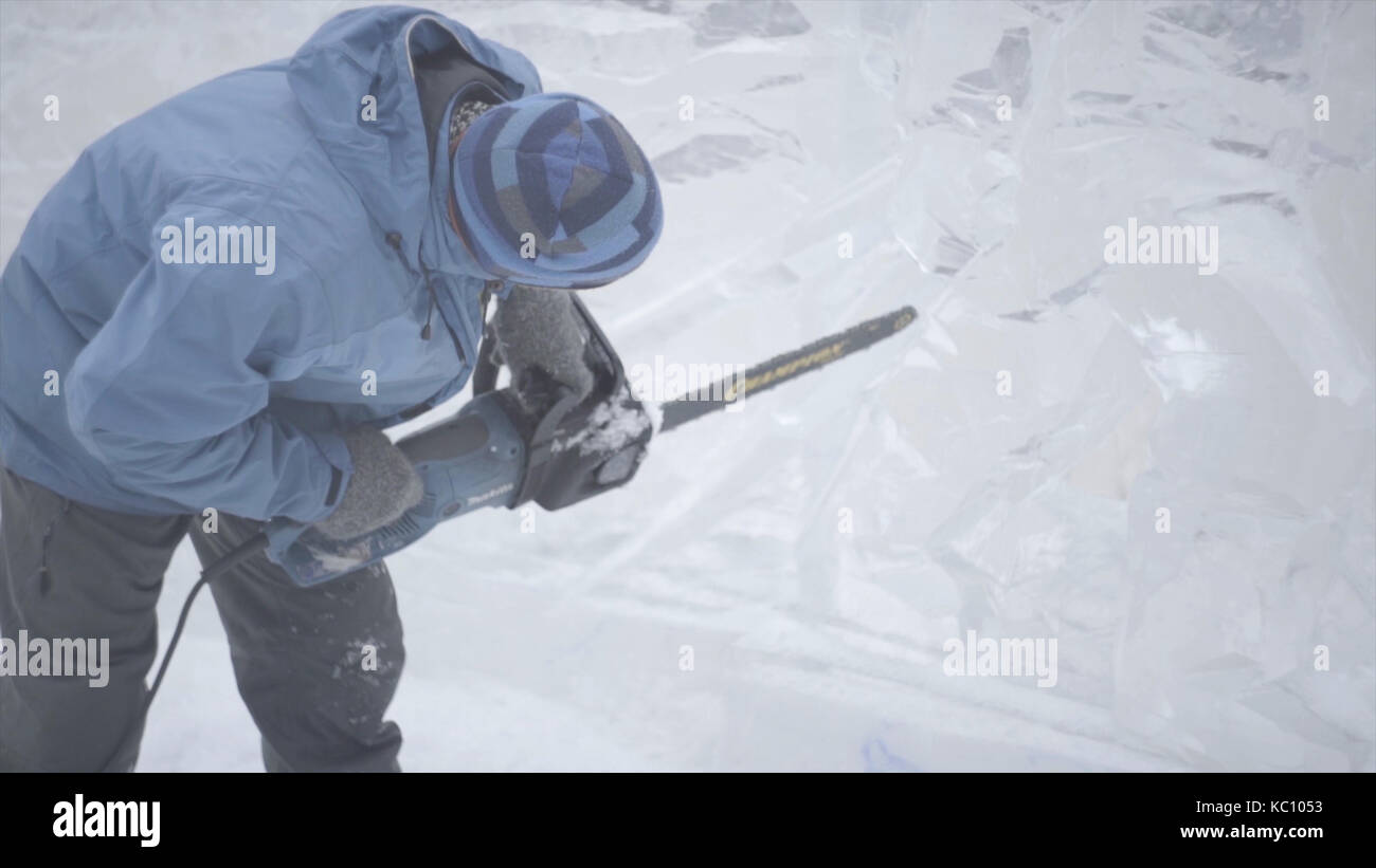 View of sculptor carving ice. Movement. Cut ice with a chainsaw. Cut ...
