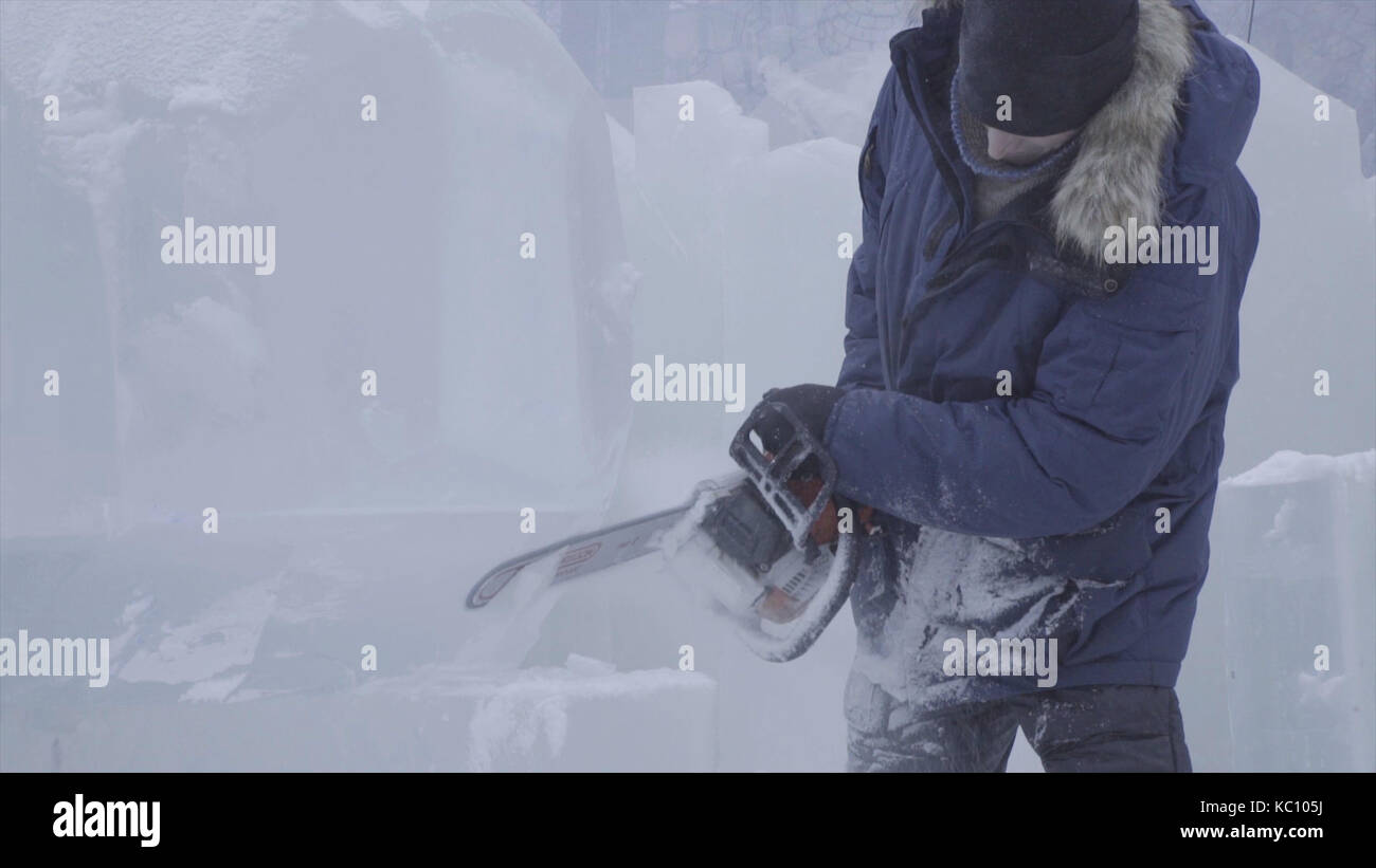 View of sculptor carving ice. Movement. Cut ice with a chainsaw. Cut ...