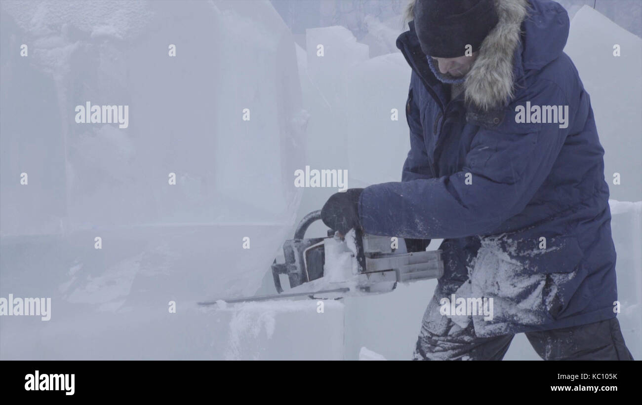 View of sculptor carving ice. Movement. Cut ice with a chainsaw. Cut ...