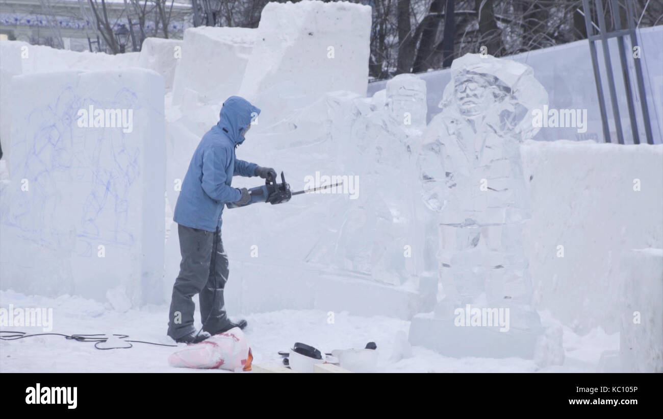 View of sculptor carving ice. Movement. Cut ice with a chainsaw. Cut ...