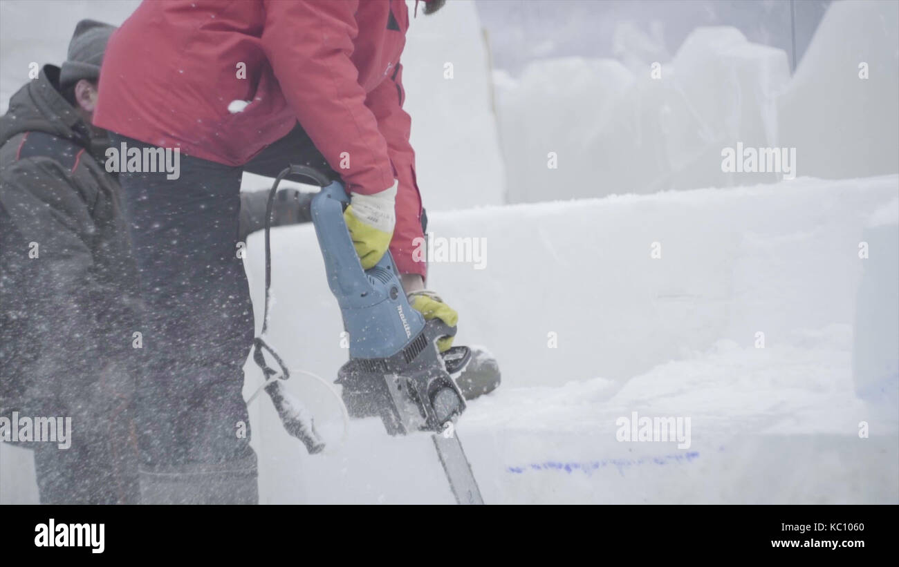 View of sculptor carving ice. Movement. Cut ice with a chainsaw. Cut ...