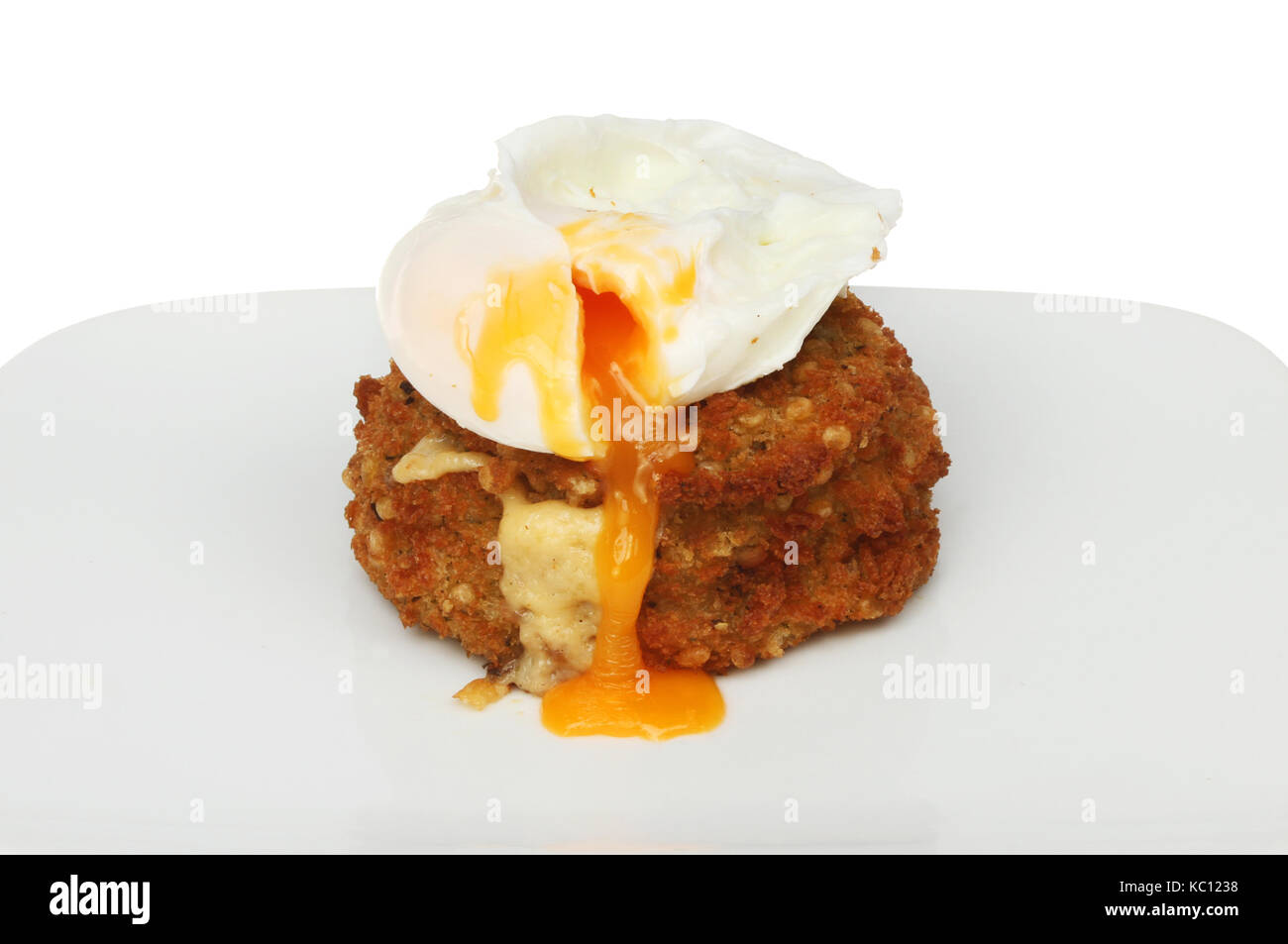 Runny yolk poached egg on a melting middle fishcake Stock Photo - Alamy