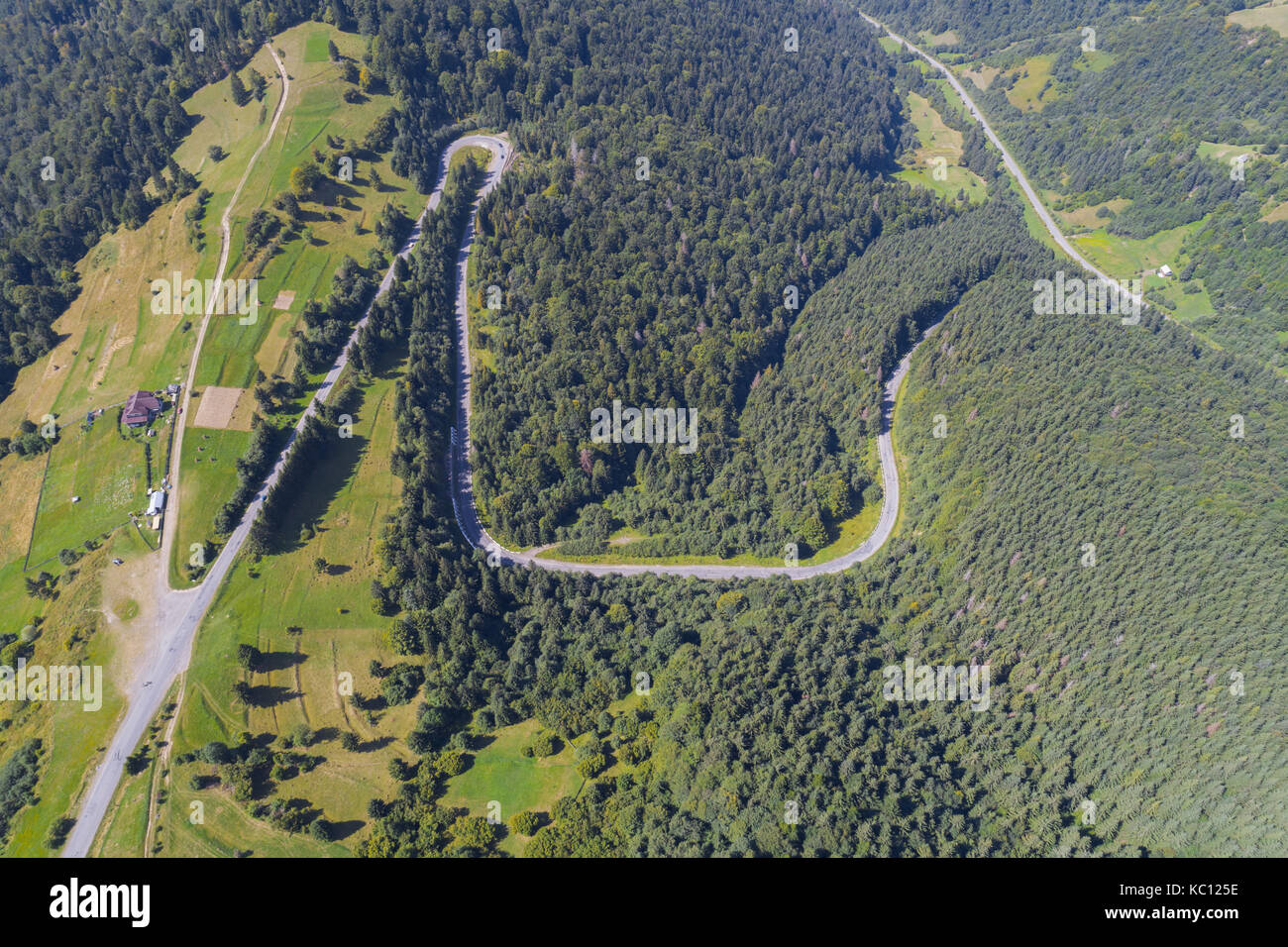 Aerial view over mountain road going through forest landscape Stock ...