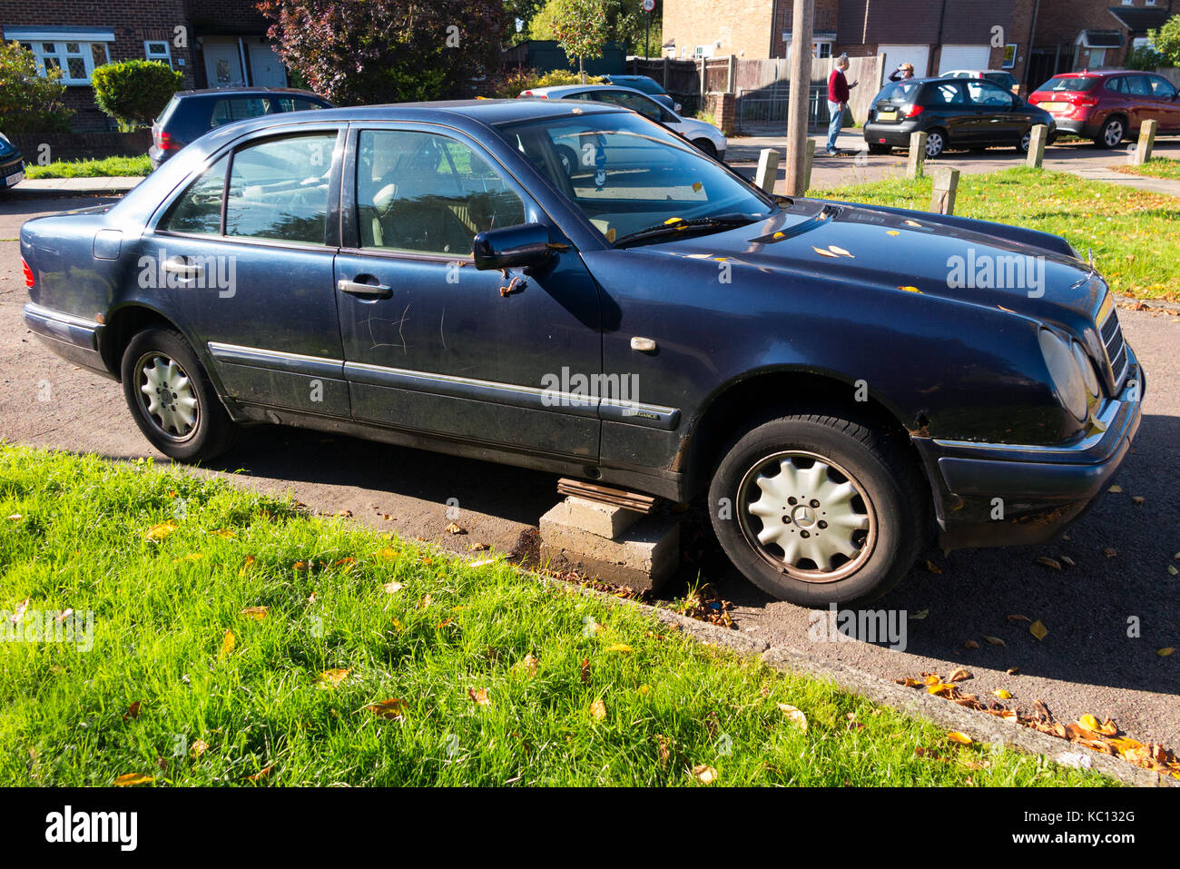 A Mercedes saloon car resting on a pile of bricks as part of a DIY home ...