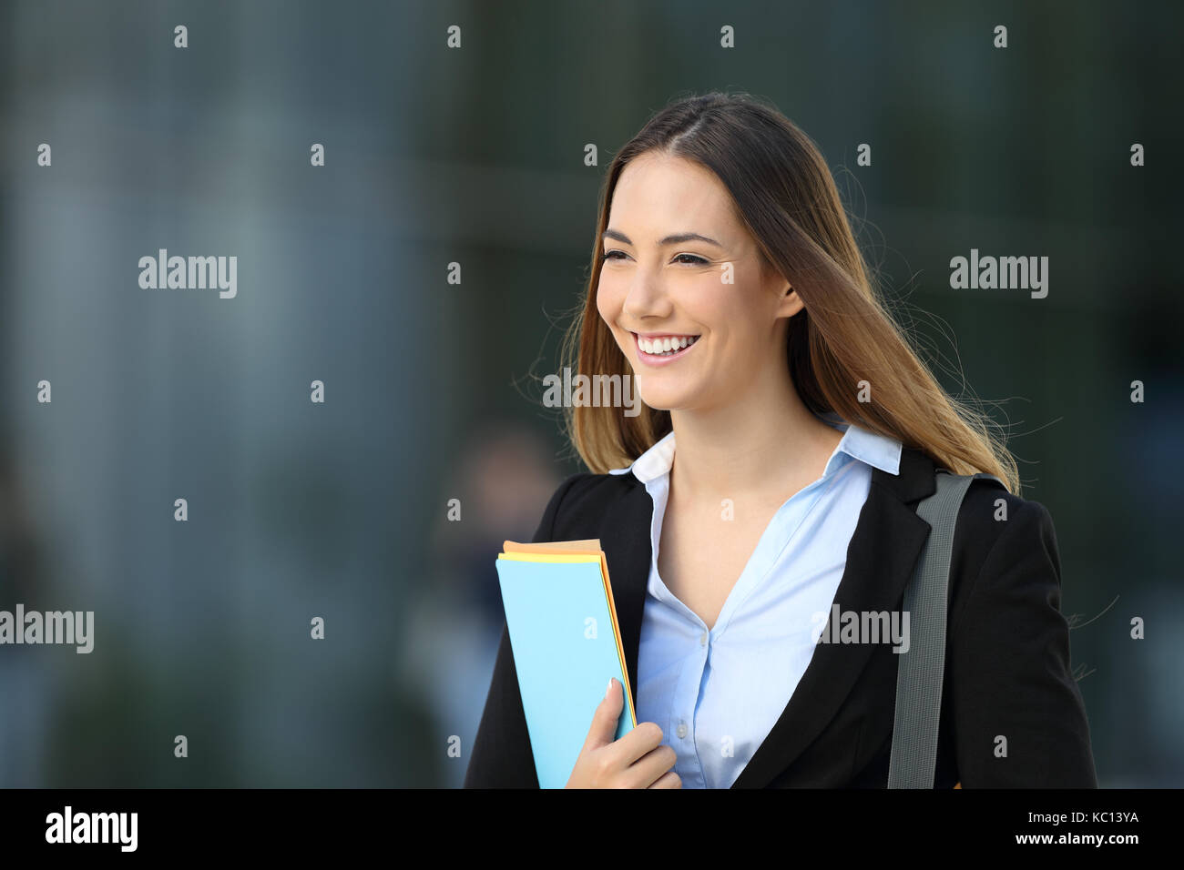 Portrait of a happy executive smiling and walking on the street Stock ...