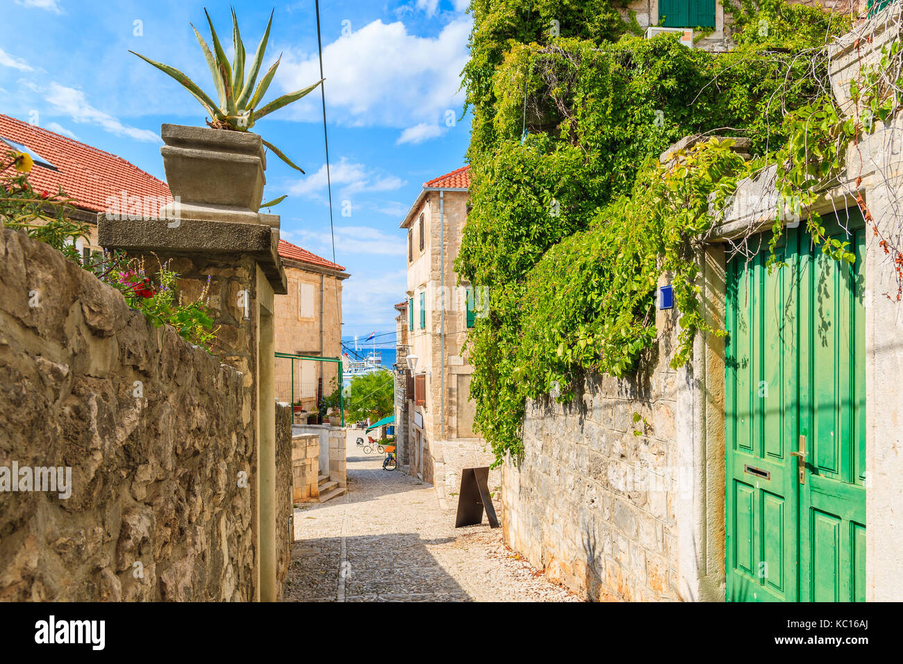 Narrow street leading to port in Postira old town, Brac island, Croatia ...