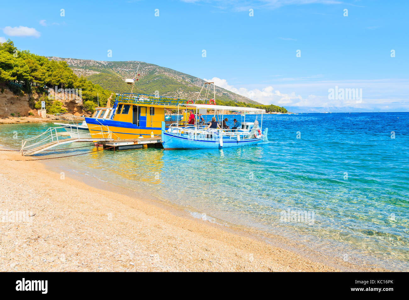 Tourist and fishing boats on beautiful Zlatni Rat beach in Bol town ...