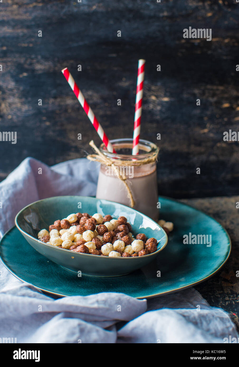 Healthy breakast corn flakes in a bowl and glass of milk on rustic ...