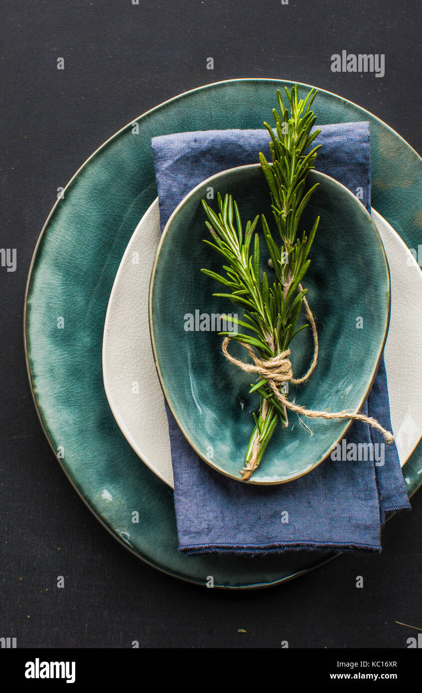 Table setting with fresh rosemary and rustic silverware on dark wooden ...