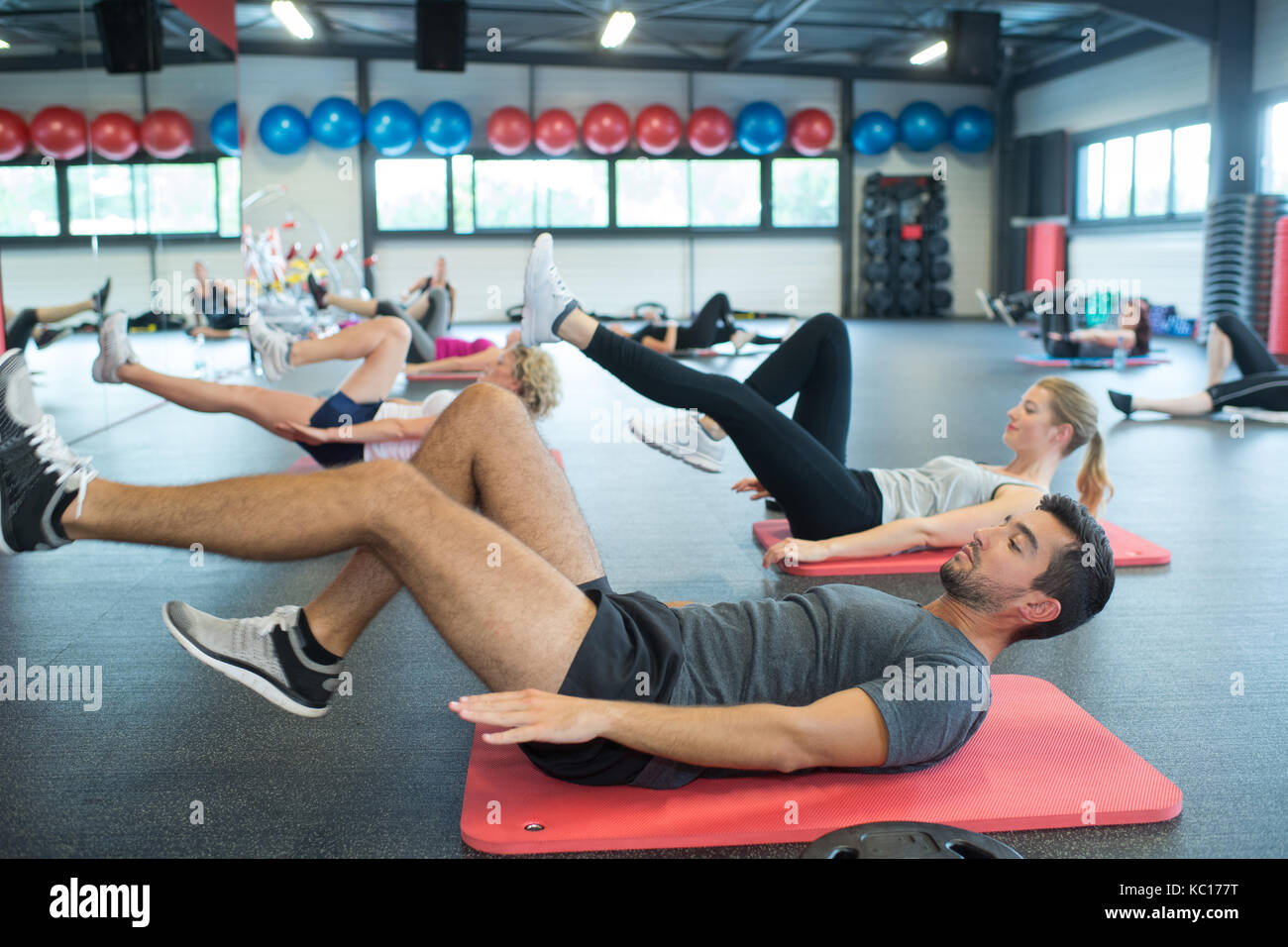 people working out on mats in gym Stock Photo - Alamy