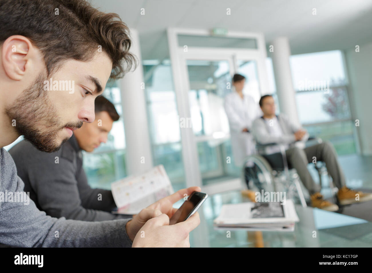 man using mobile phone while waiting a at clinic Stock Photo - Alamy