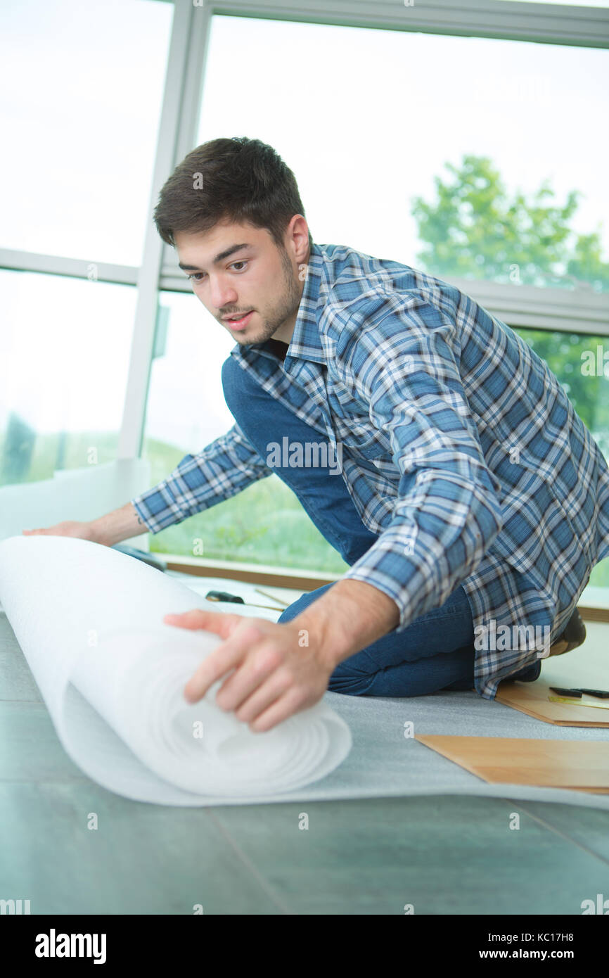 Man laying insulation on floor Stock Photo - Alamy