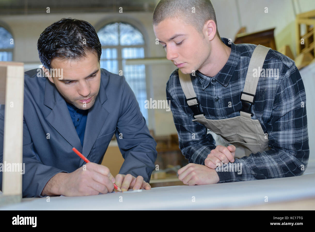carpenter and apprentice working with wood Stock Photo - Alamy