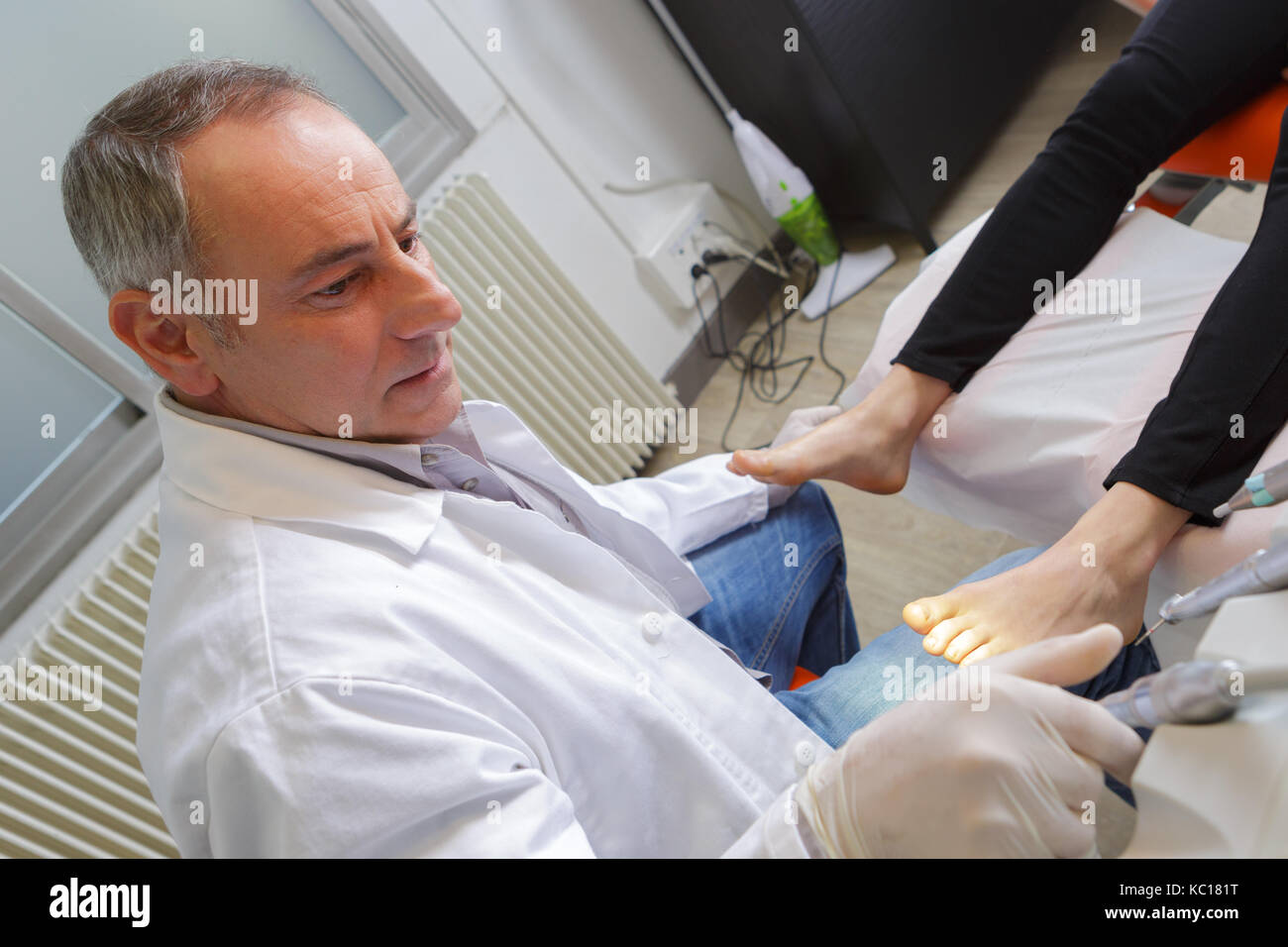 podiatrist cleaning womans feet Stock Photo - Alamy