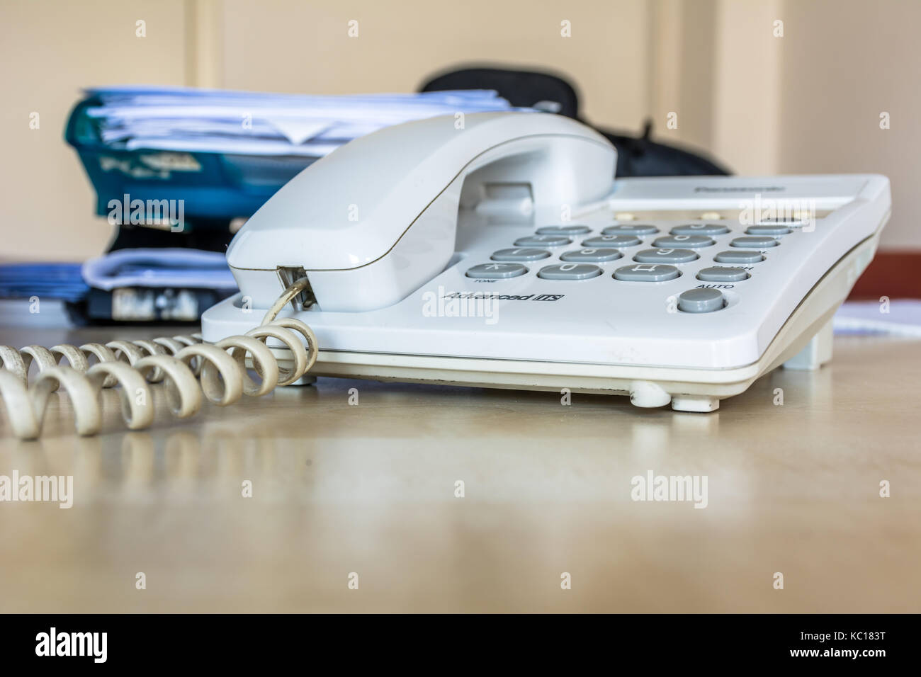 Old white office phone with cord on the table Stock Photo - Alamy