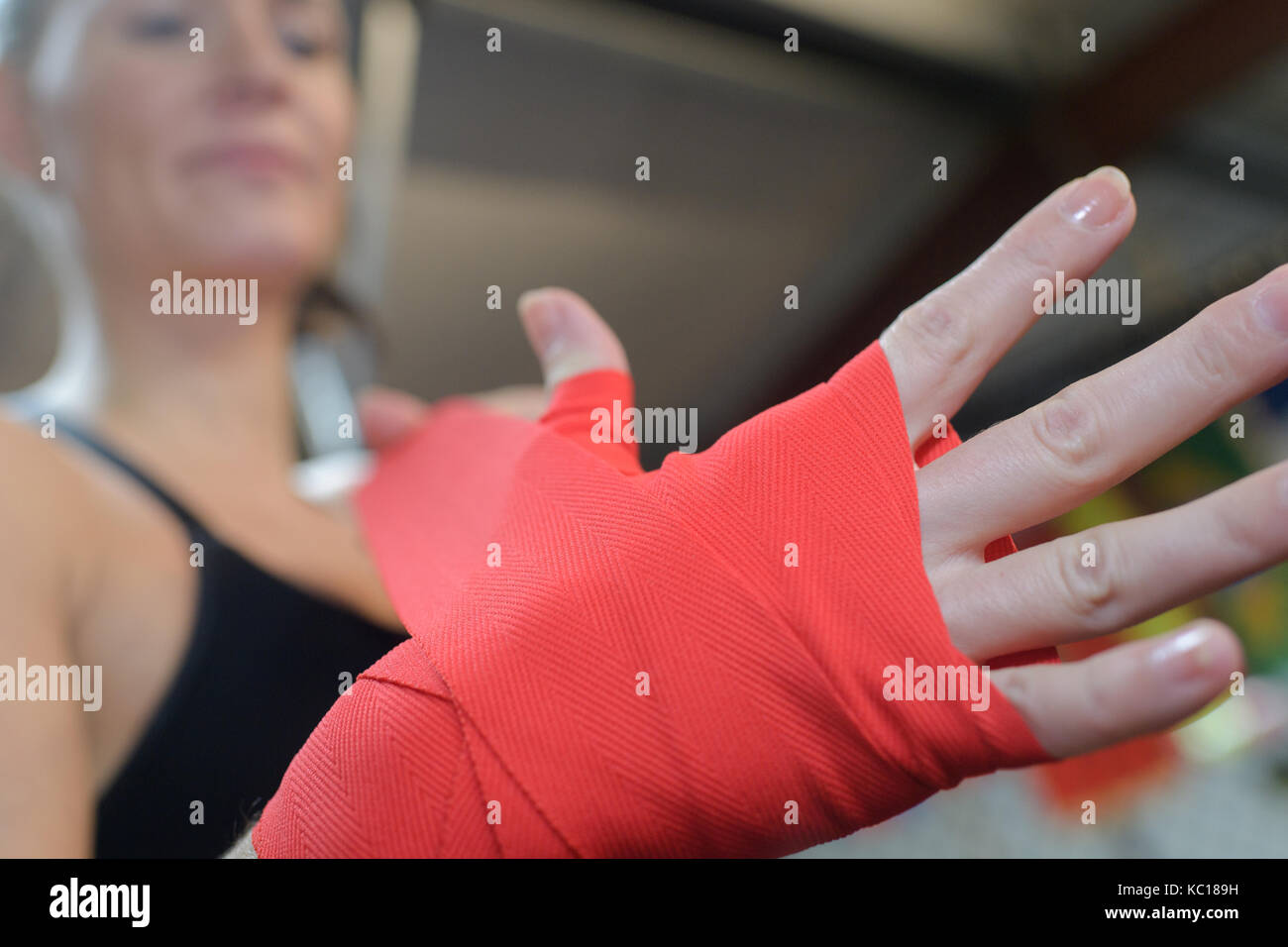 woman is wrapping hands with red boxing hand wraps Stock Photo - Alamy