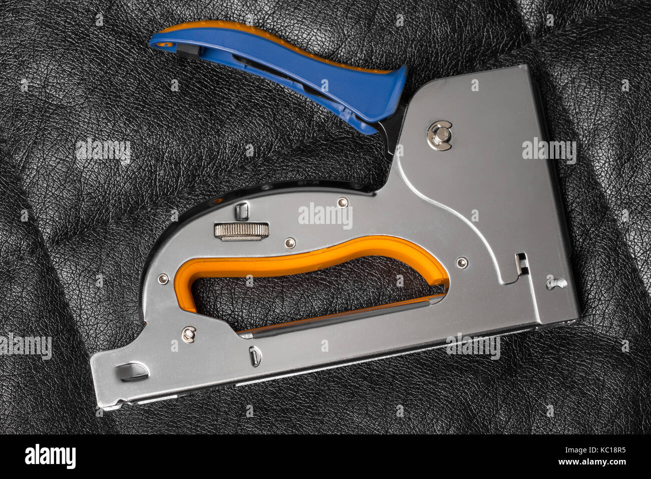 Construction stapler on a leather couch Stock Photo - Alamy