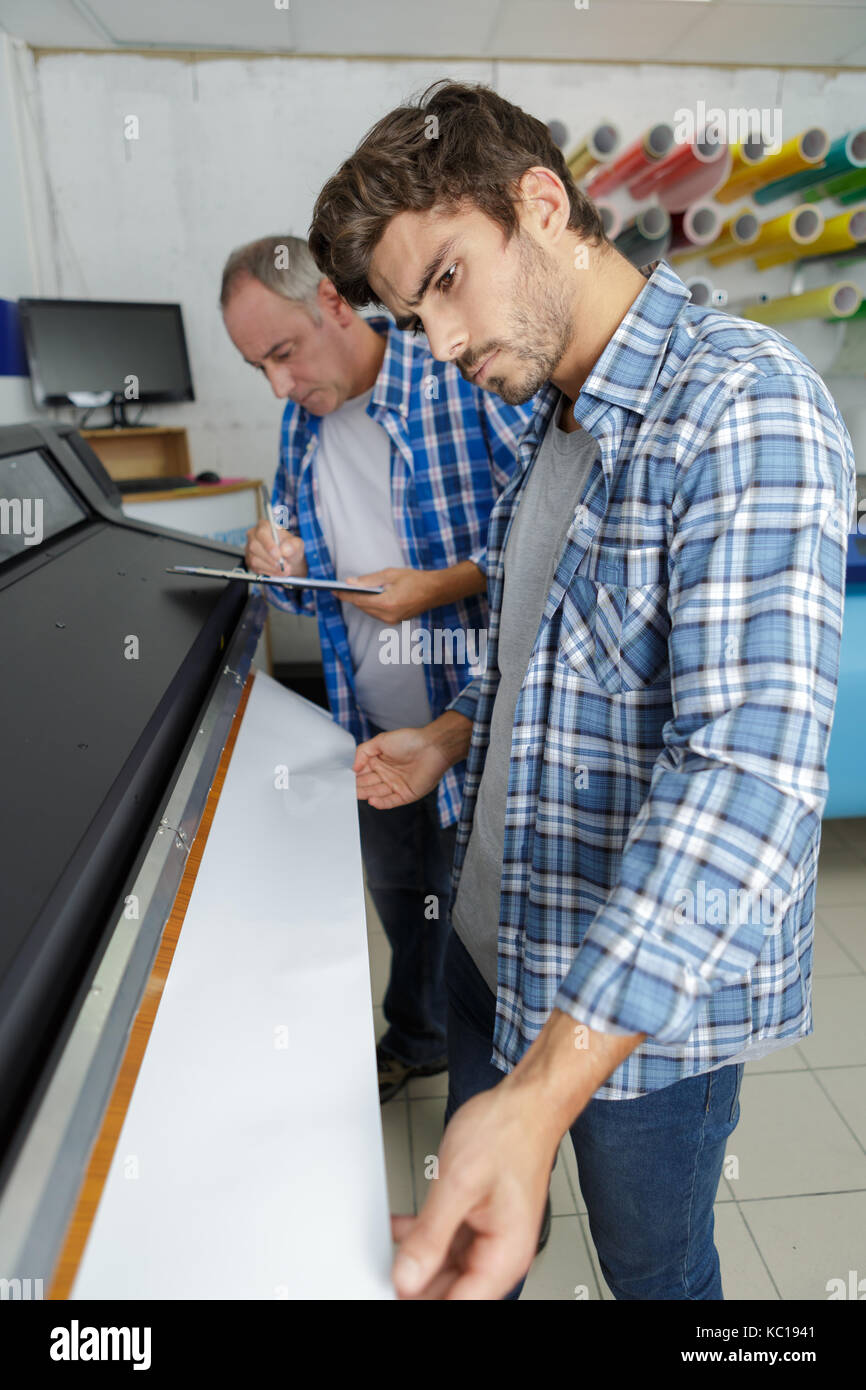 man pushing huge roll of paper in newspaper factory Stock Photo - Alamy