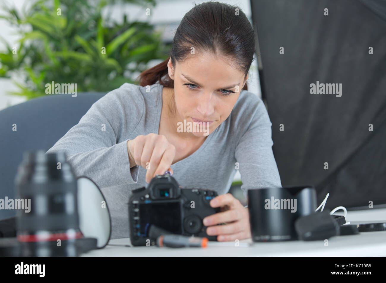 beautiful woman fixing camera Stock Photo - Alamy