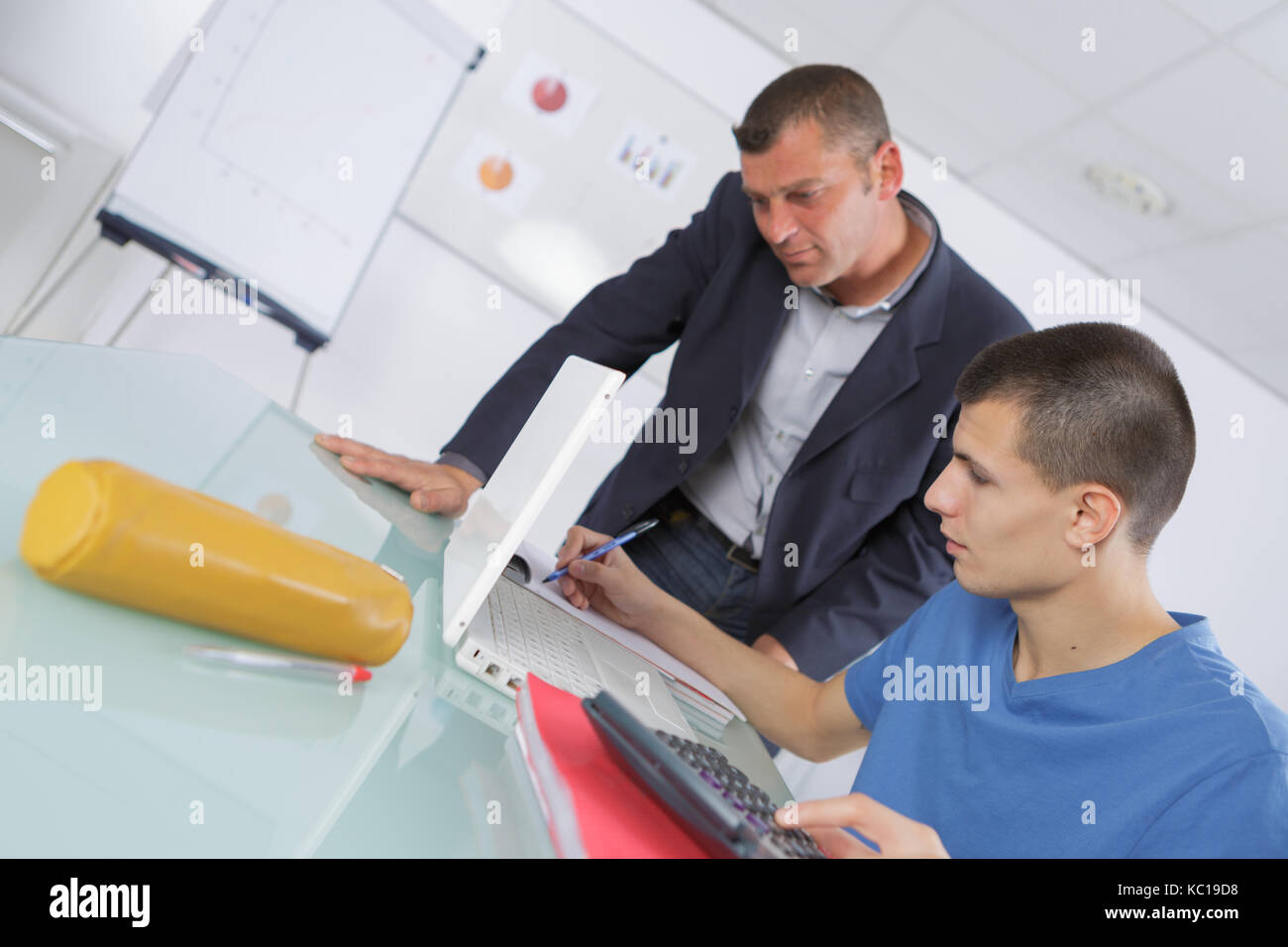 teacher helping the student Stock Photo - Alamy