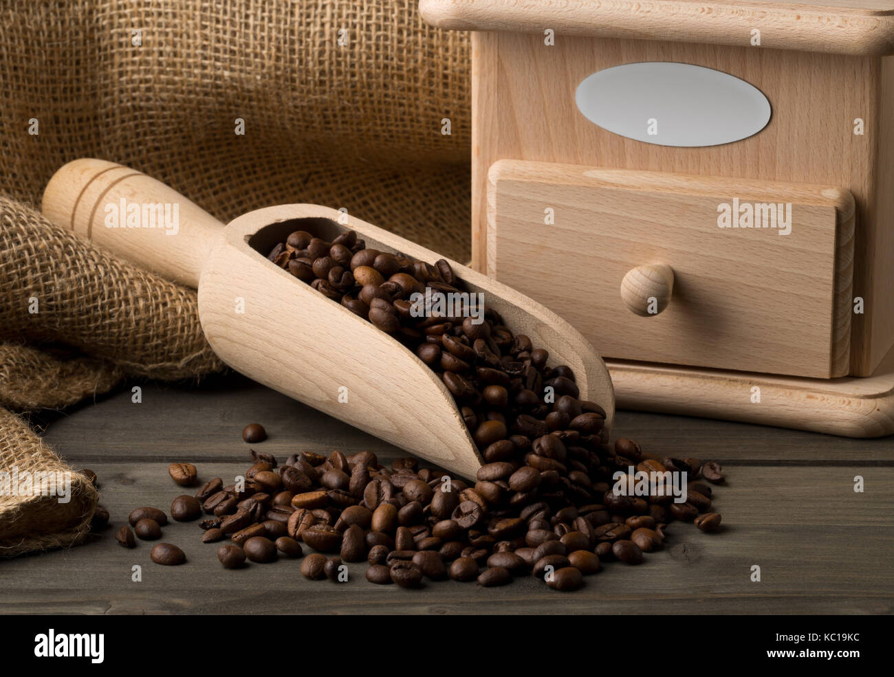 Coffee beans in wooden scoop with wooden coffee bean grinder on dark ...