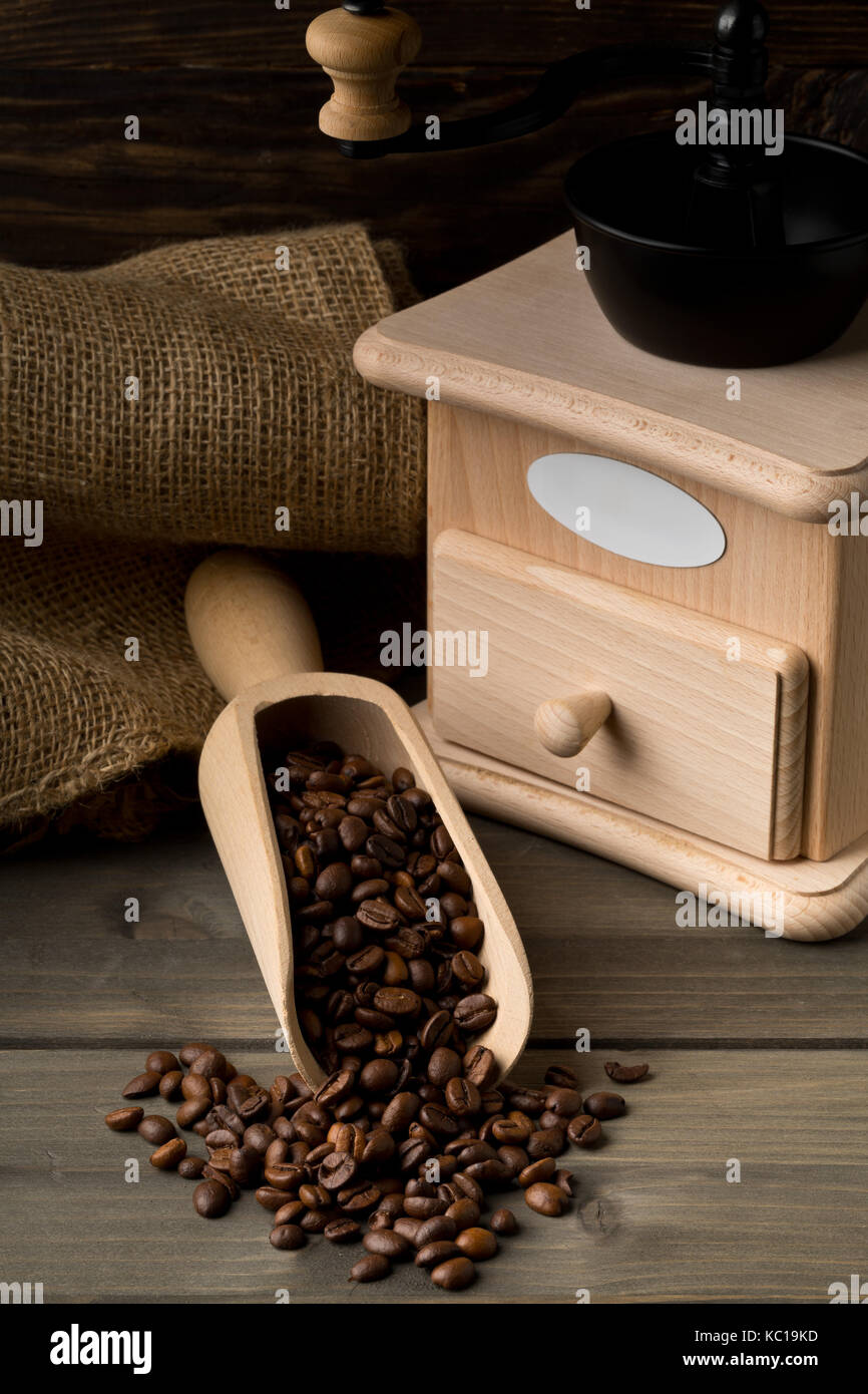 Coffee beans in wooden scoop with wooden coffee bean grinder on dark ...